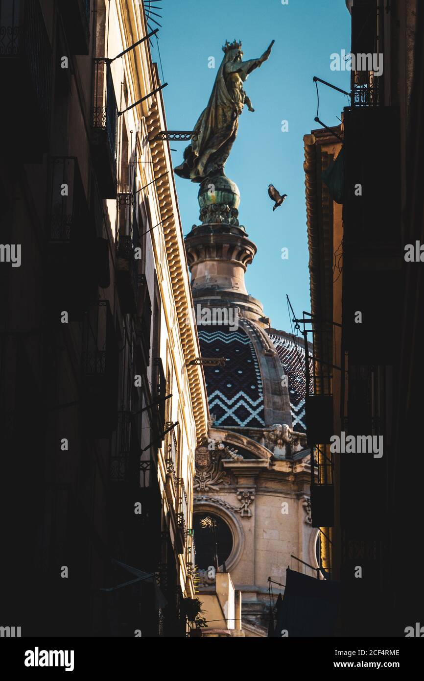 From below shiny ancient statue with raised hand on dome of ...