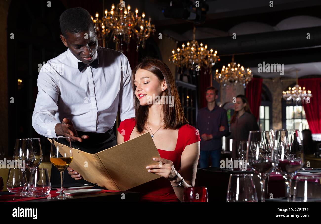 African-american waiter receiving order from guest in fashionable ...