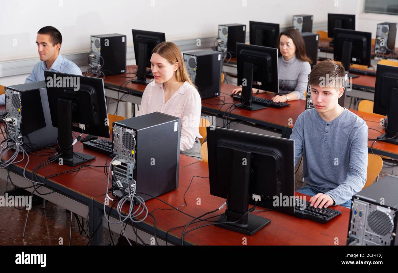 adult concentrated people of different ages learning to use computers ...