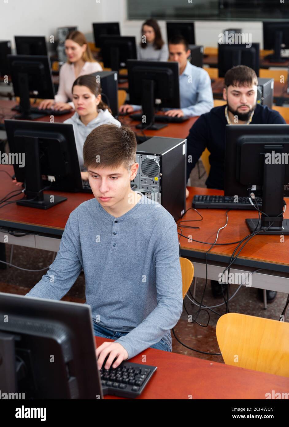 Group of people of different ages learning to use computers in ...