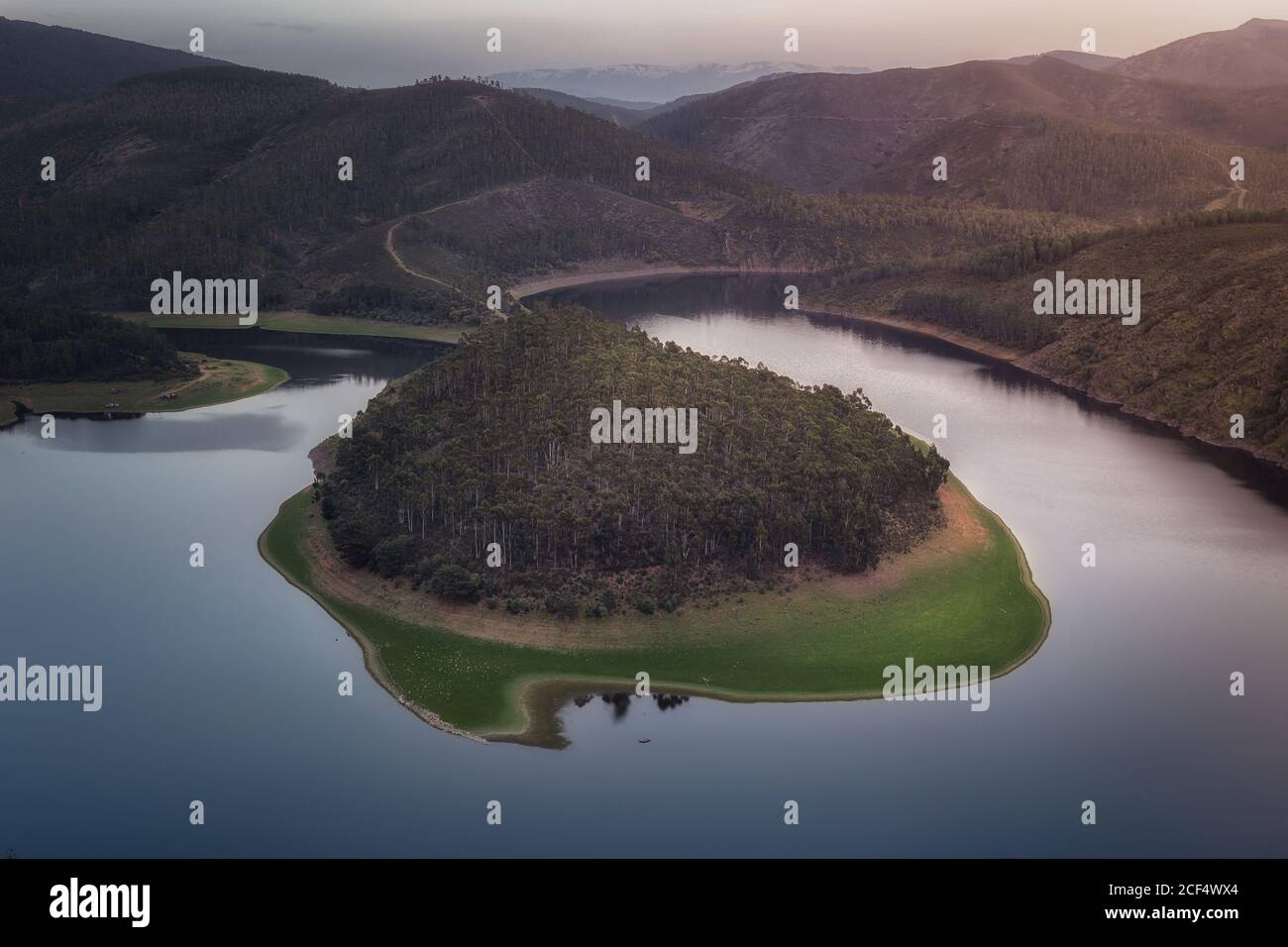 Aerial view of wooded island on smooth surface of lake in deserted ...