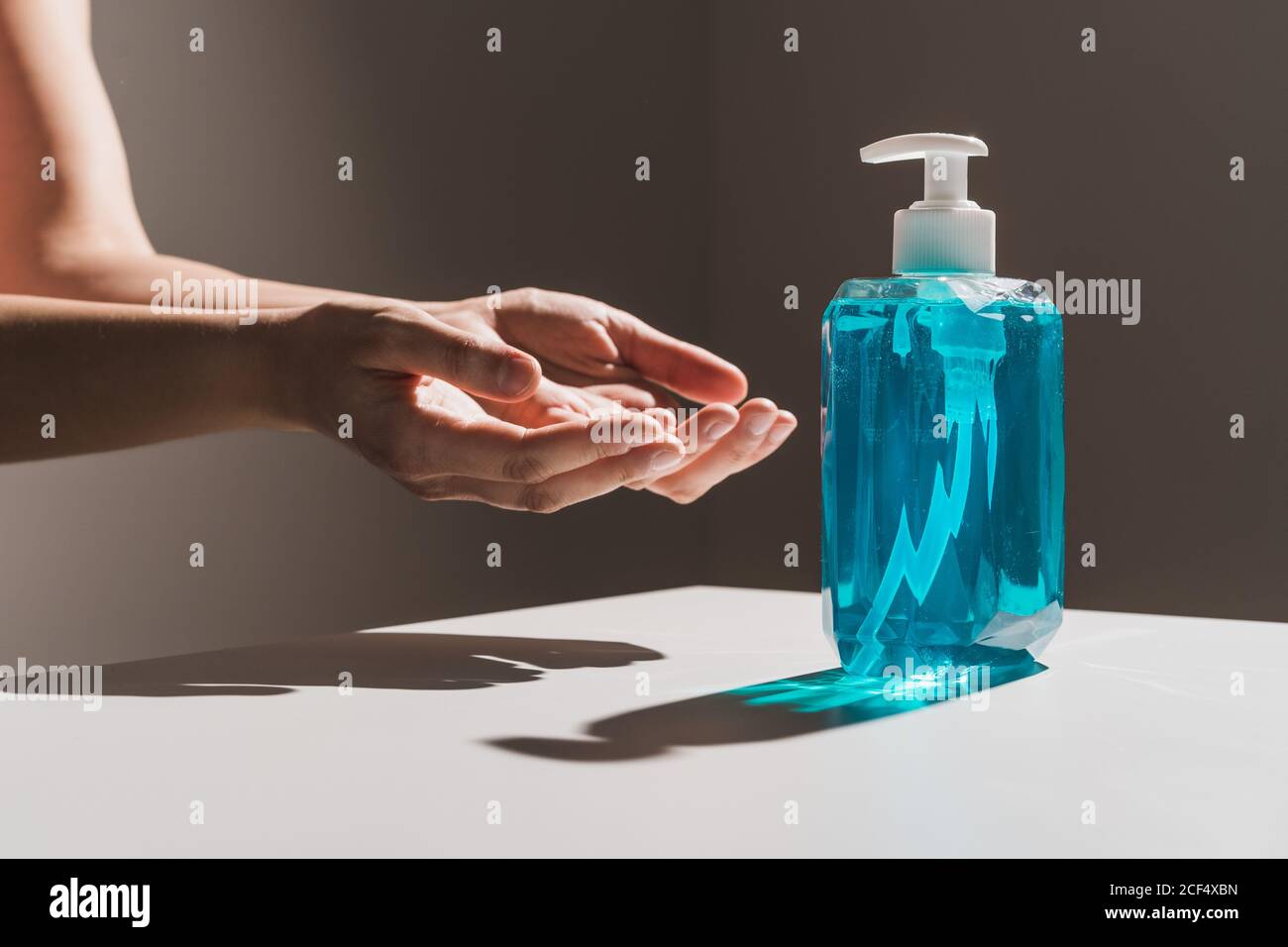 Flow of blue liquid soap coming out of dispenser Stock Photo - Alamy