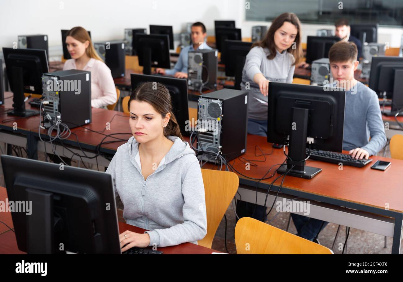 Serious female student works at computer in university class Stock ...