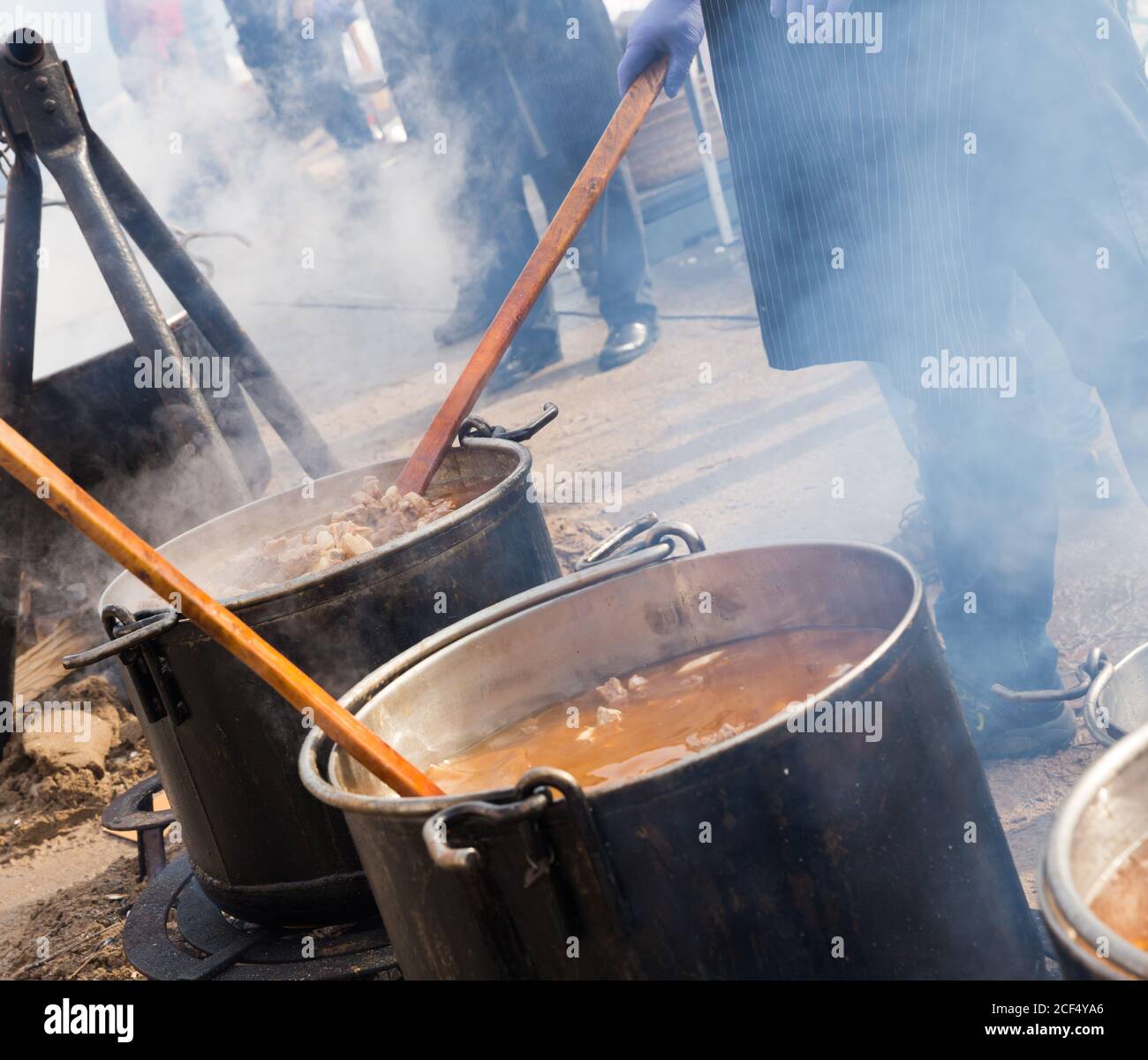 Preparation of food in bowlers on bonfire, cooking outdoor in a ...