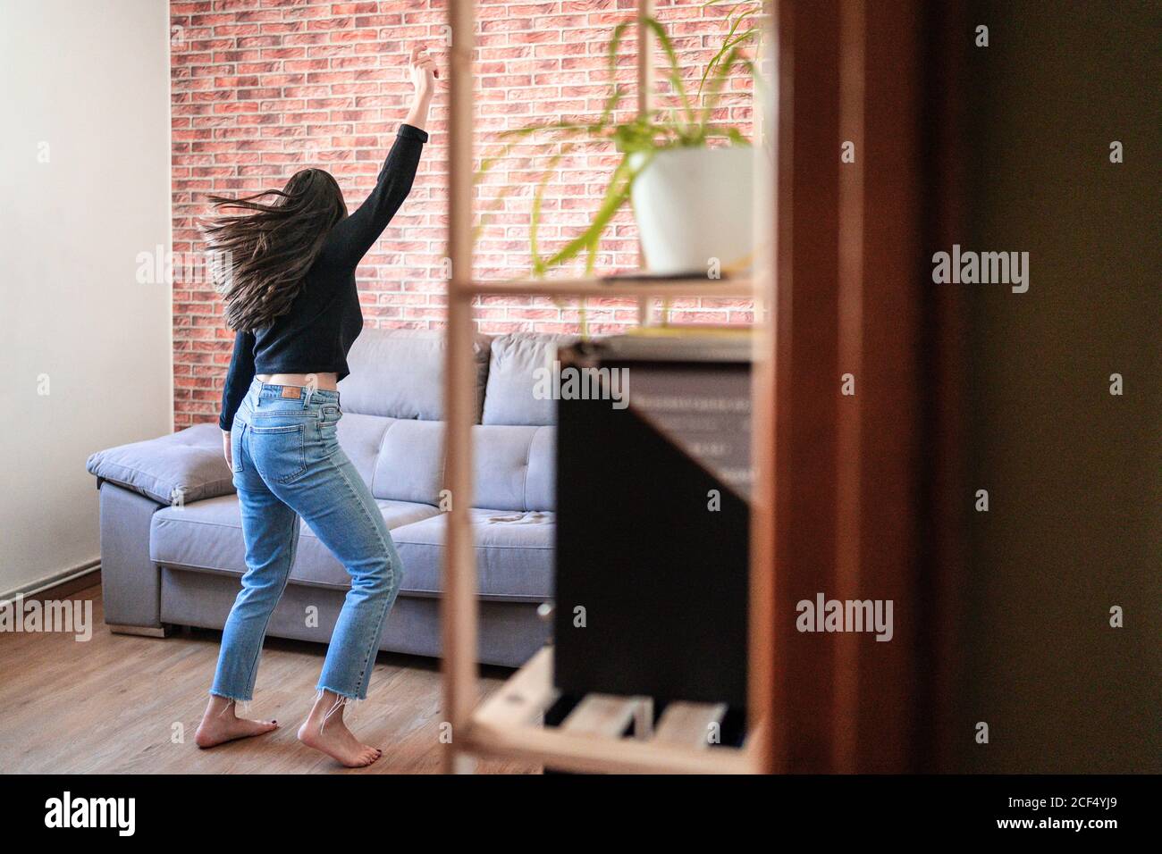 anonymous Woman dancing at home. She's got her back turned. Behind it ...