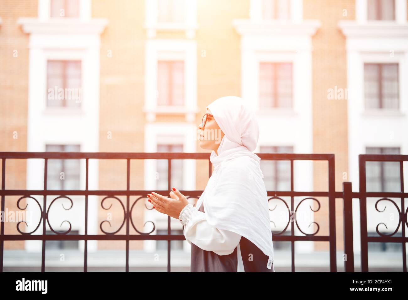 Islamic woman praying outdoor. White hijab. Side view Stock Photo - Alamy