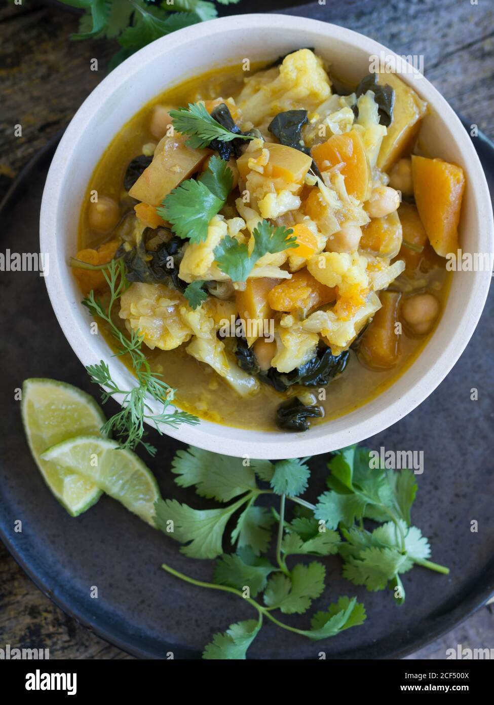 From above plate with delicious vegetarian curry and lime slices placed ...