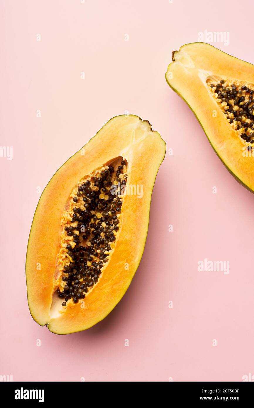 Top view of open papaya on pink background Stock Photo - Alamy