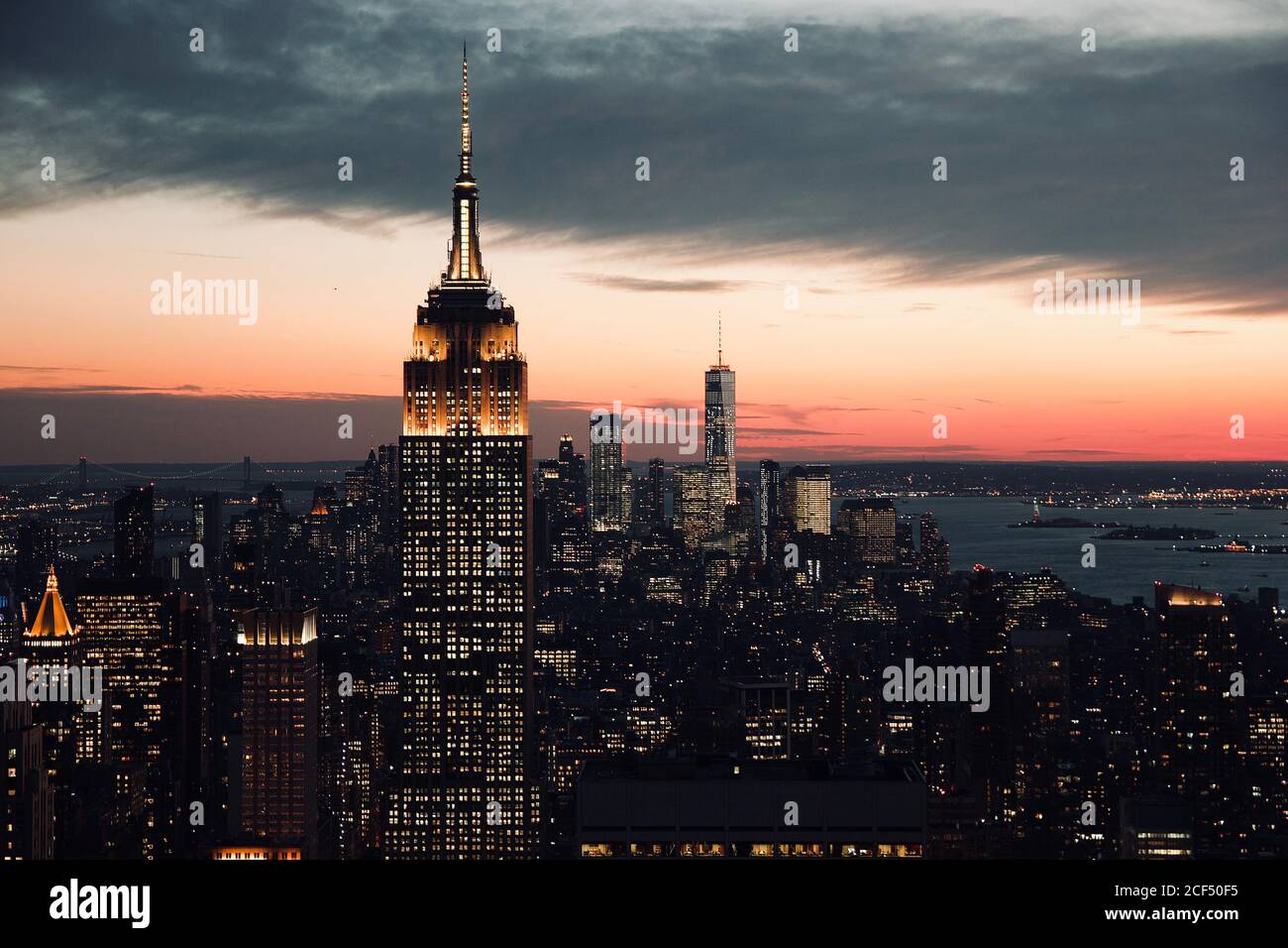 Aerial view of city with tall skylines with illuminated windows during ...
