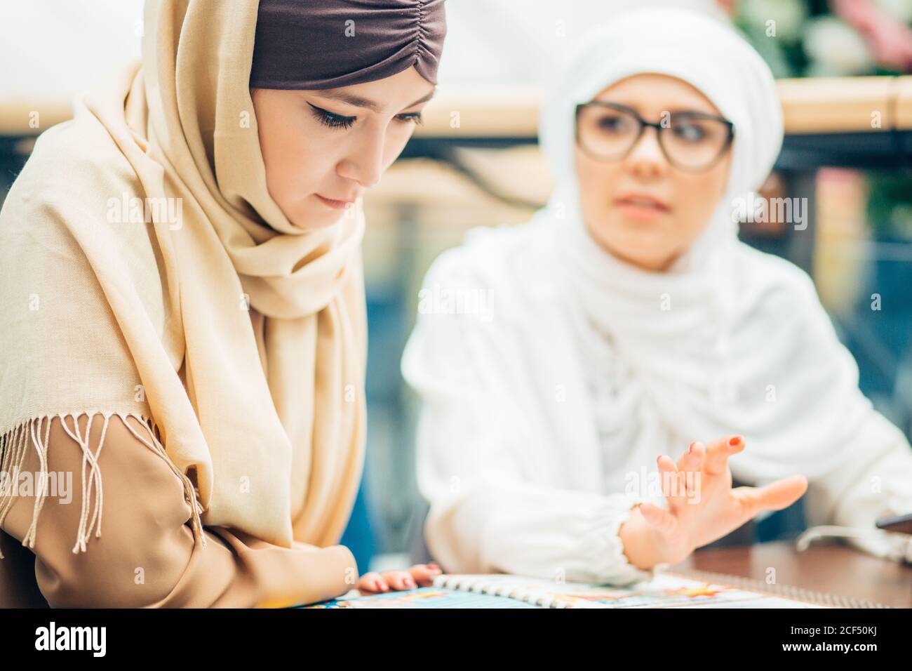 Two Young Muslim Friends Enjoying Meal In Outdoor Restaurant Stock ...