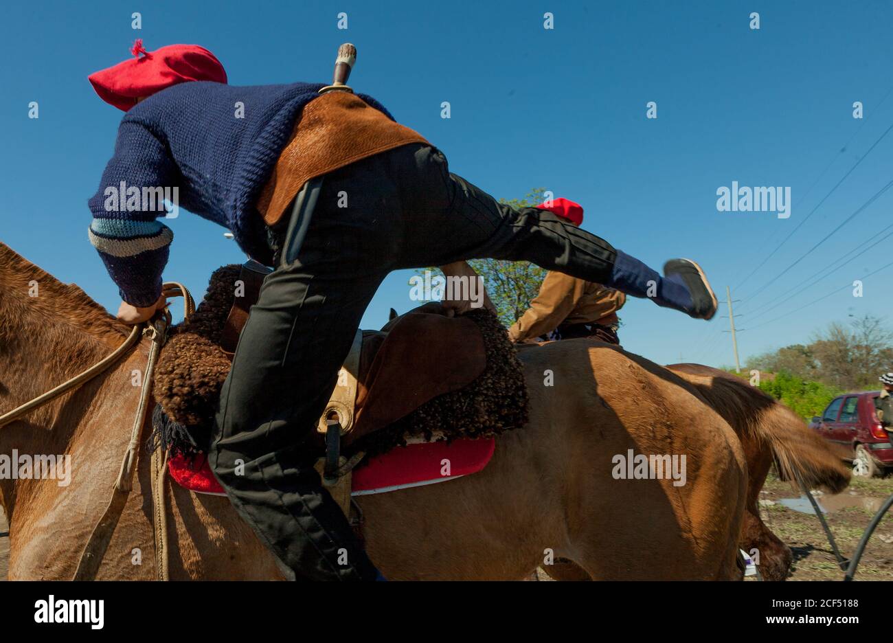 Back view of horse rider in warm outfit and cap jumping on brown horse ...