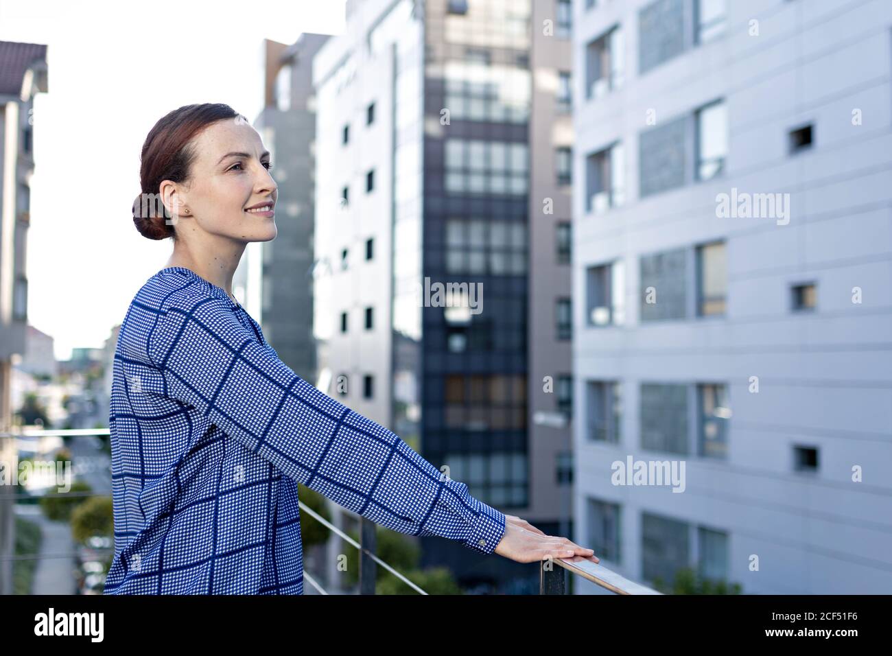Side view of pretty female manager in checkered shirt smiling and ...