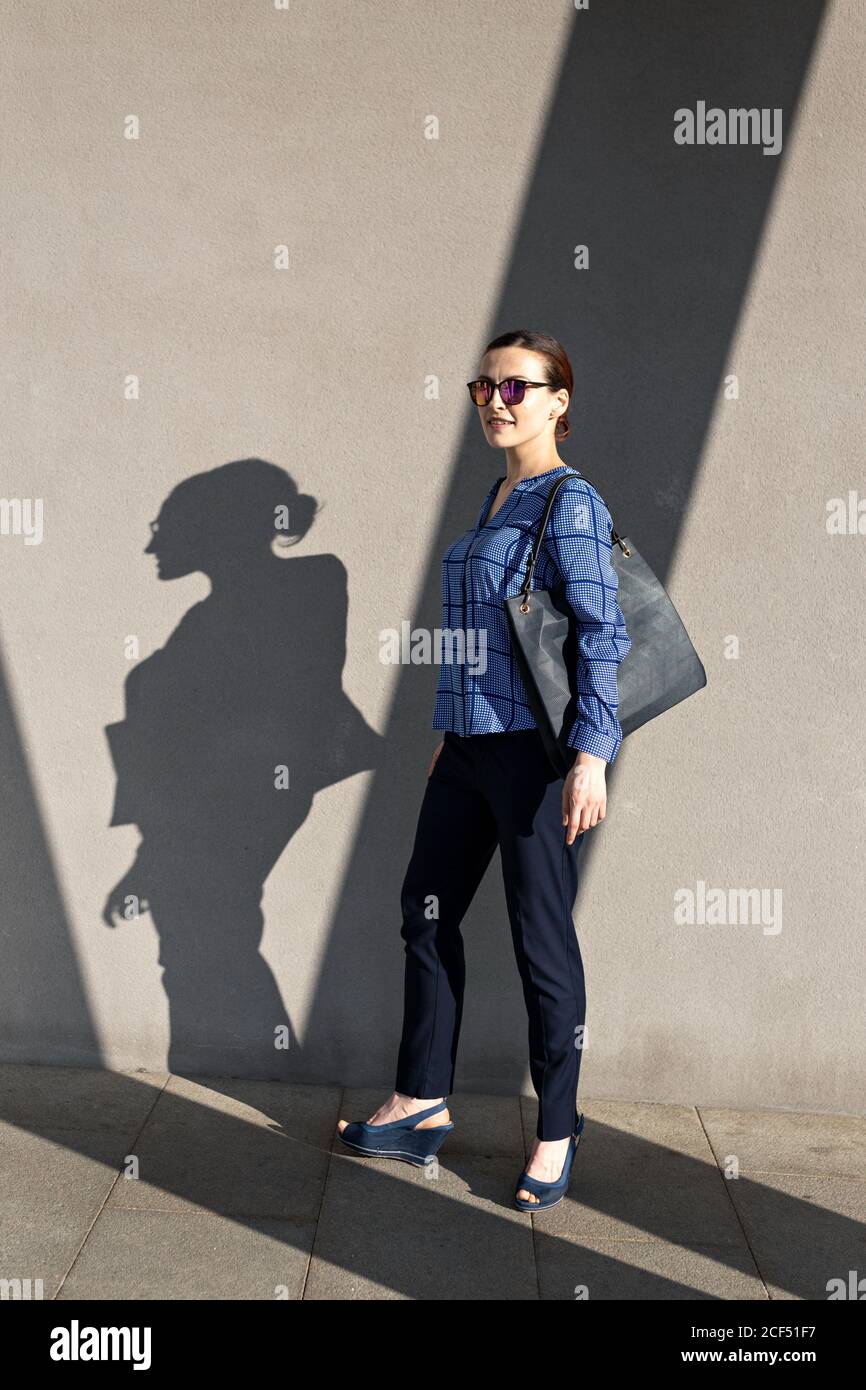 Full body female manager in sunglasses and elegant outfit smiling and ...