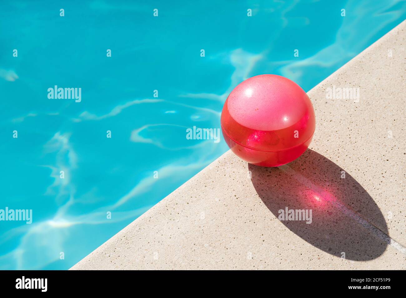 Red ball on the edge of swimming pool on summertime Stock Photo - Alamy