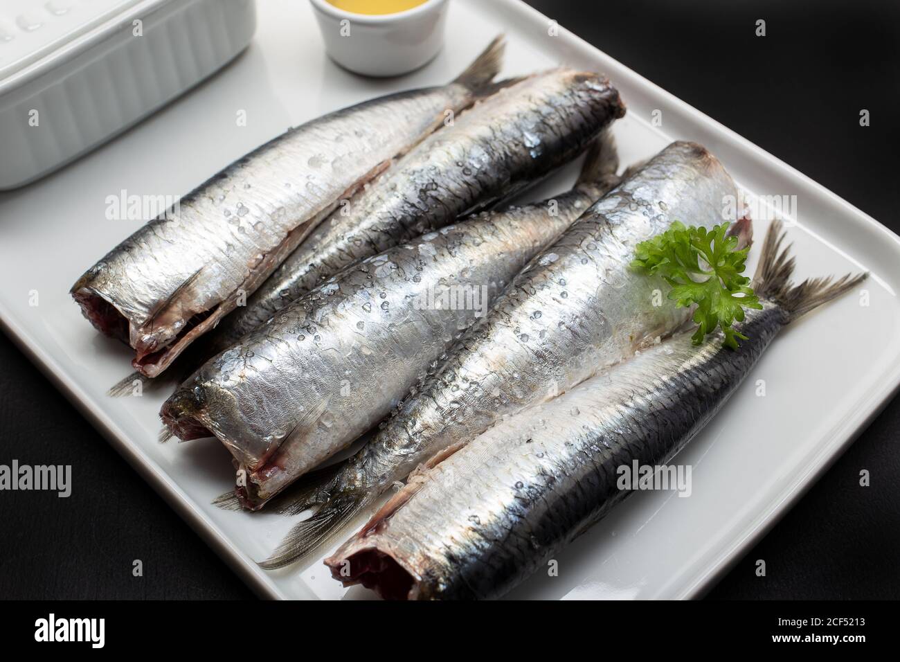 Fresh washed and scaled fish without heads on white plate Stock Photo ...