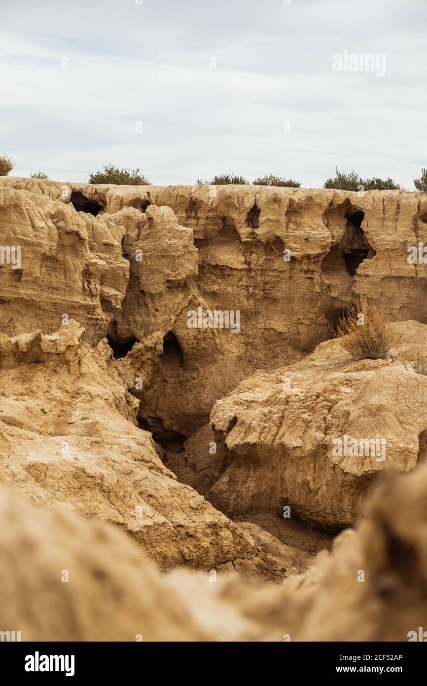 Dried big rocks with green sparse vegetation under blue sky and white ...