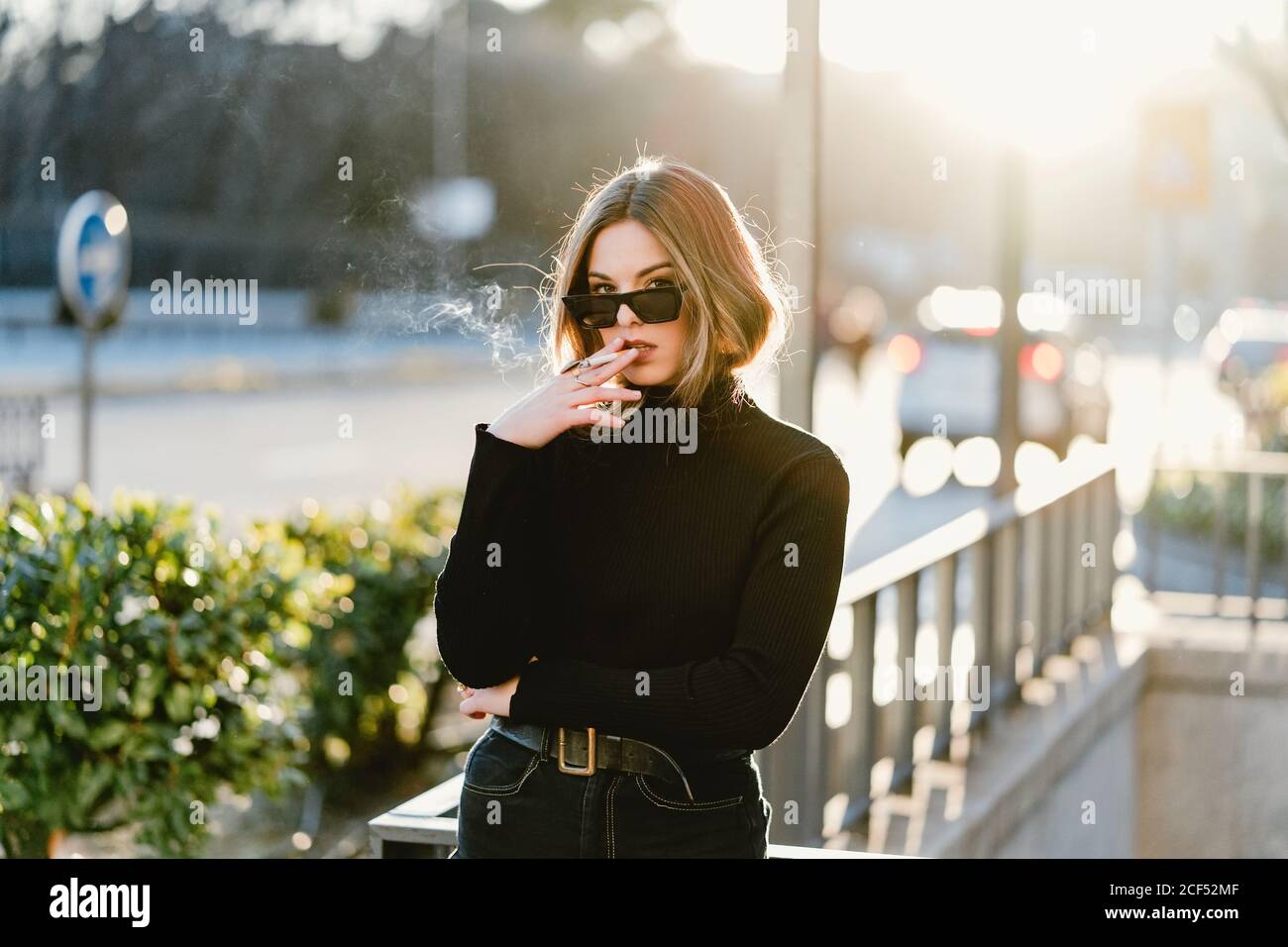 Beautiful young woman lighting cigarette hi-res stock photography and ...