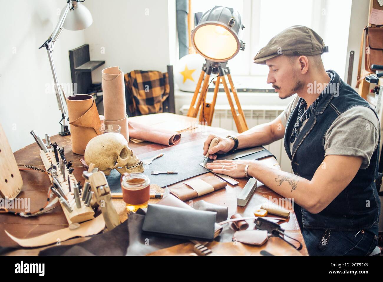 Portrait of modern handsome craftsman wearing creative cup focused on ...