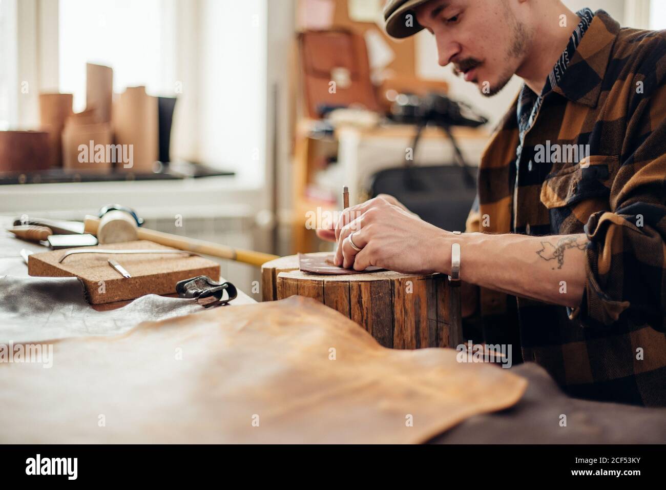 Portrait of modern handsome craftsman wearing creative cup focused on ...