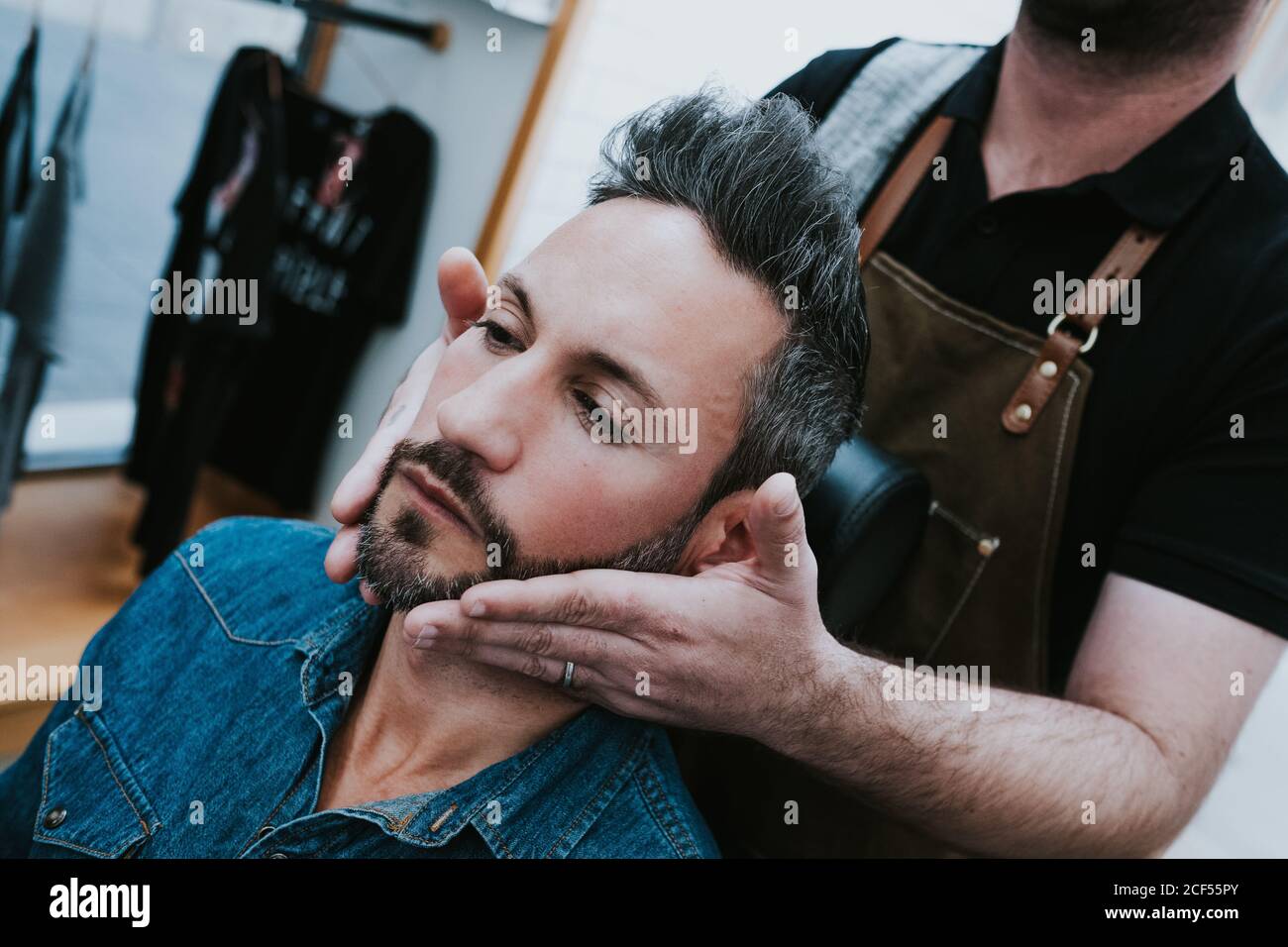 Crop barber doing face massage to handsome stylish male with closed ...