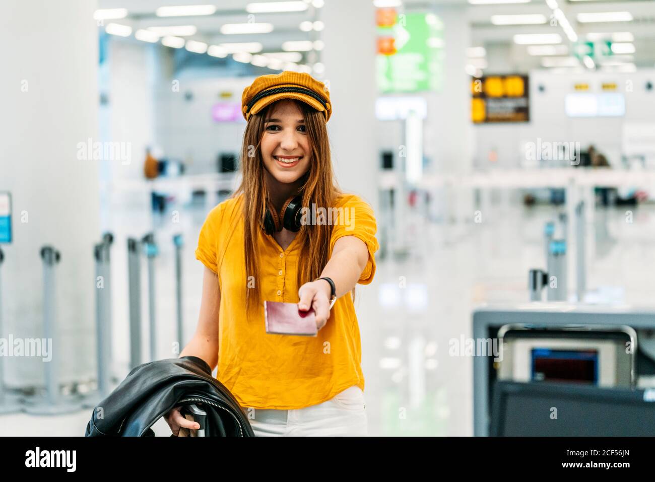 Cheerful smiling lady in colorful stylish clothes and headphones giving ...