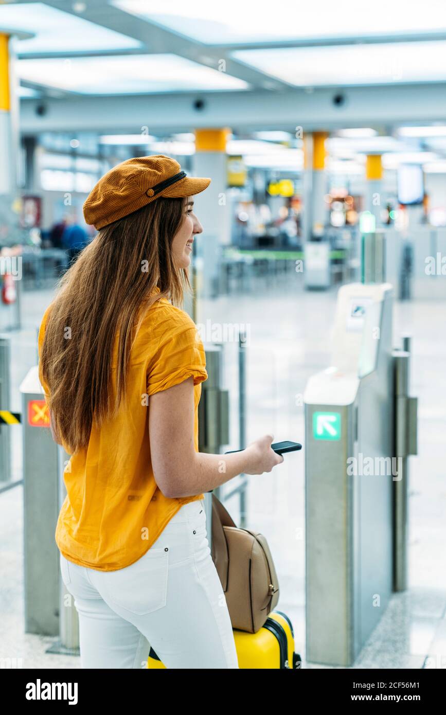 female passenger in fashionable outfit standing next to check in ...
