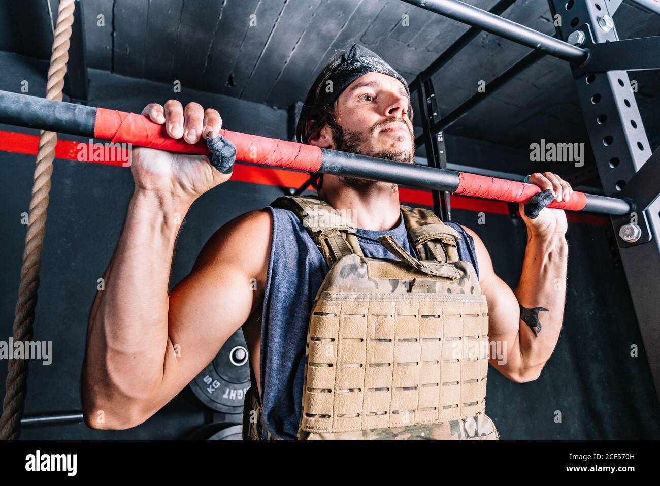 Strong man doing pull-up exercise with weight on horizontal bar Stock ...