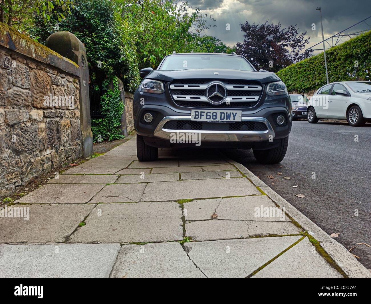 A car parks on the pavement / sidewalk, restricting space for ...