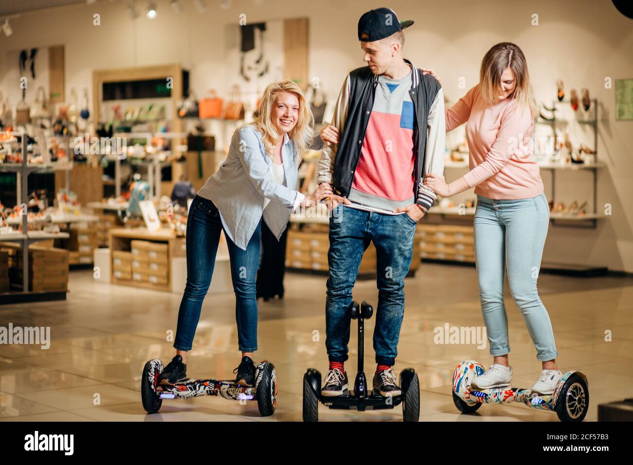 young man and two woman riding on the Hoverboard in mall. content ...