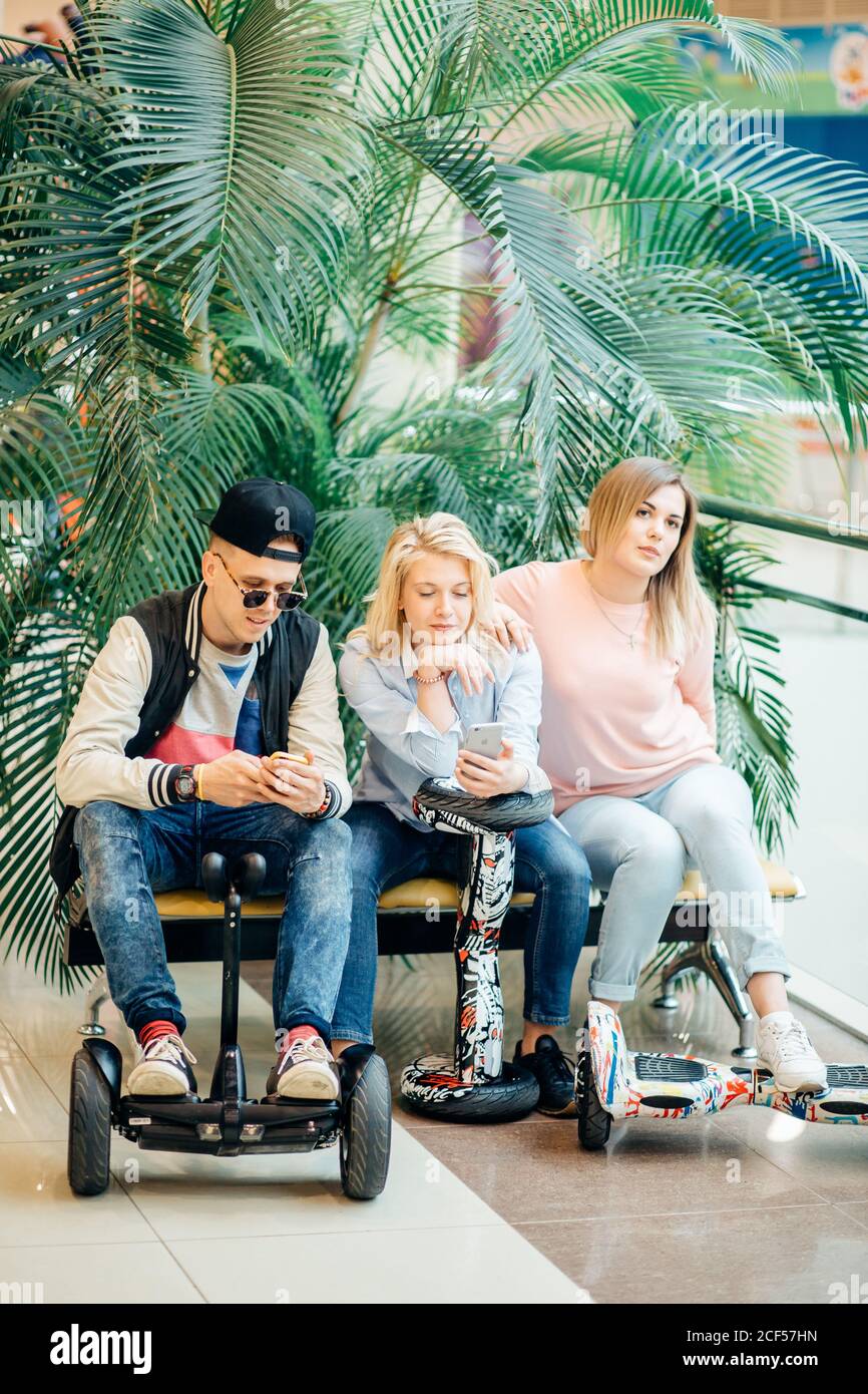 group of modern people with electric scooter hoverboard sitting at ...