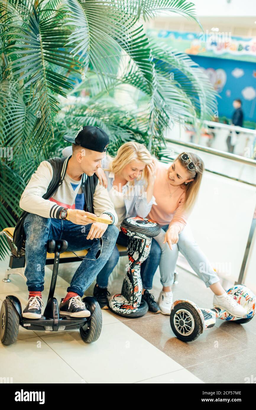 group of modern people with electric scooter hoverboard sitting at ...