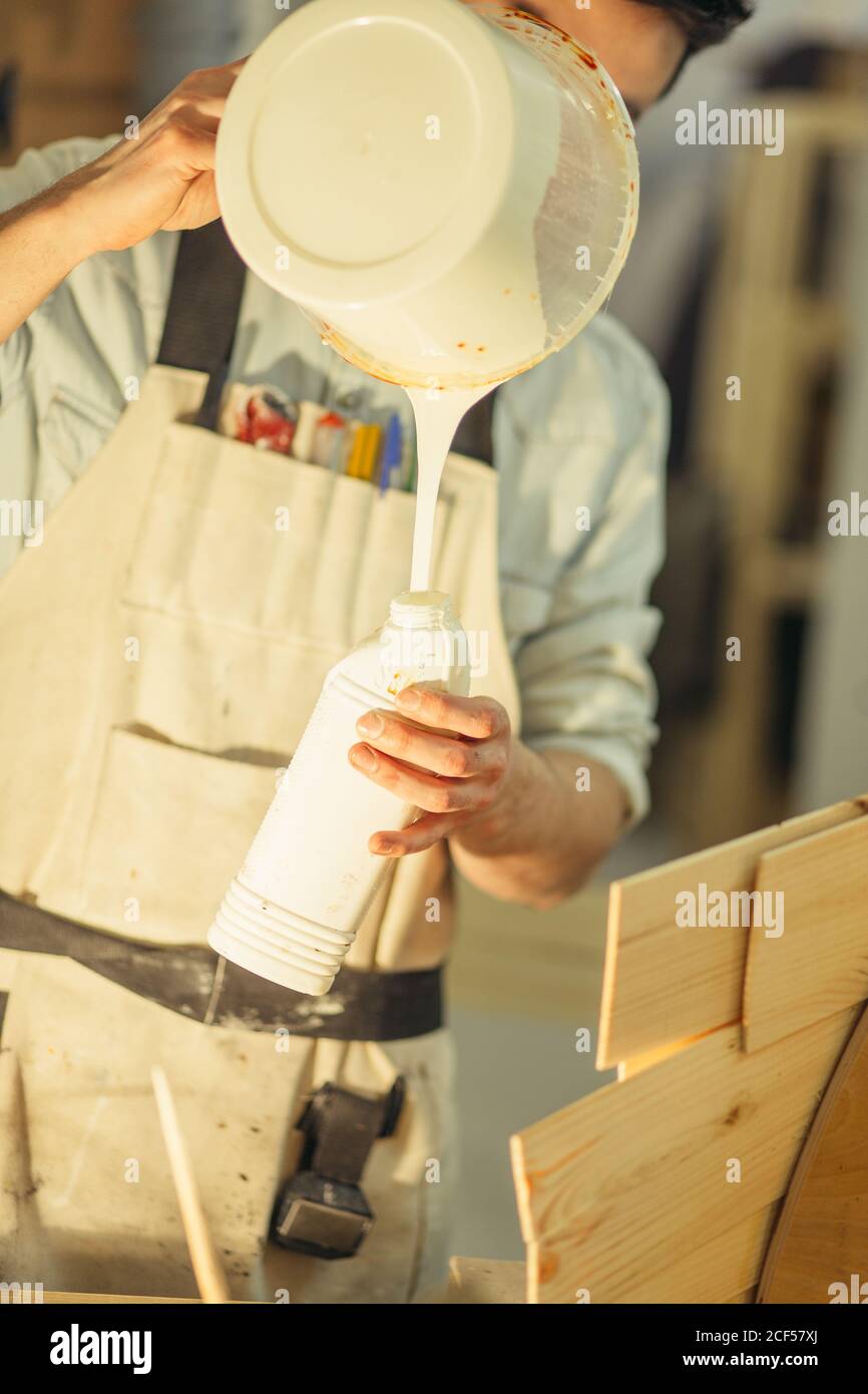 Happy carpenter holding a bottle with glue. Process of creating ...