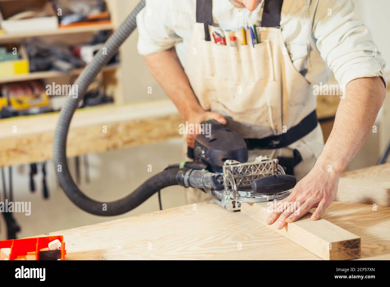 Carpenter planing timber in the light workshop Stock Photo - Alamy