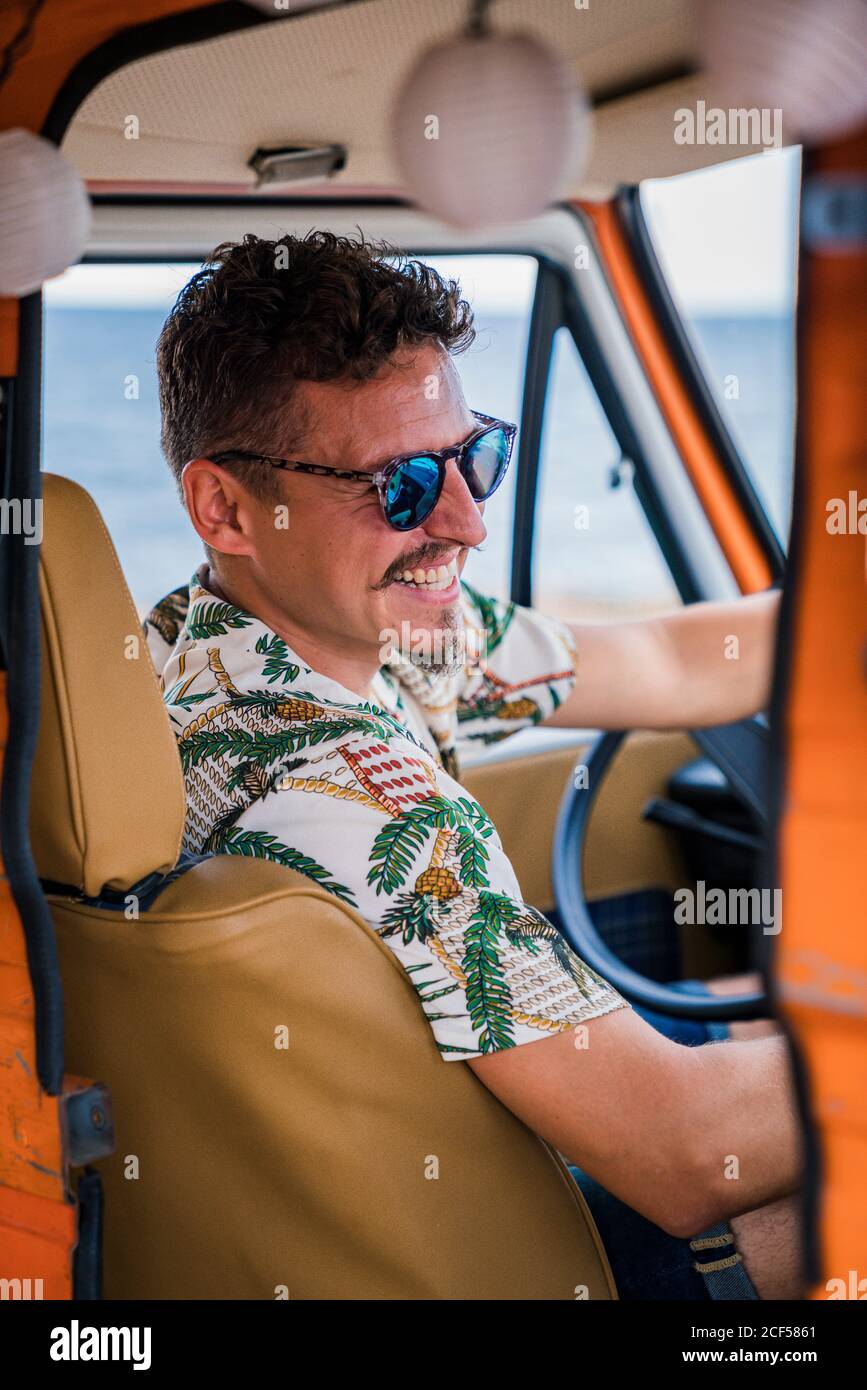 Stylish mustache man in sunglasses and colorful shirt holding steering ...