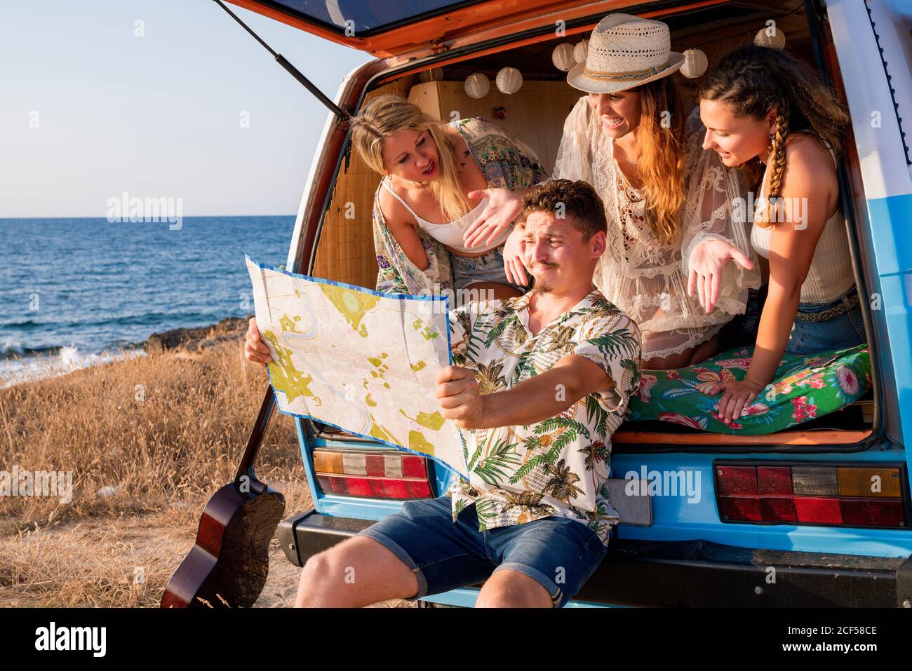 Active curios man looking at open road map and finding route with ...