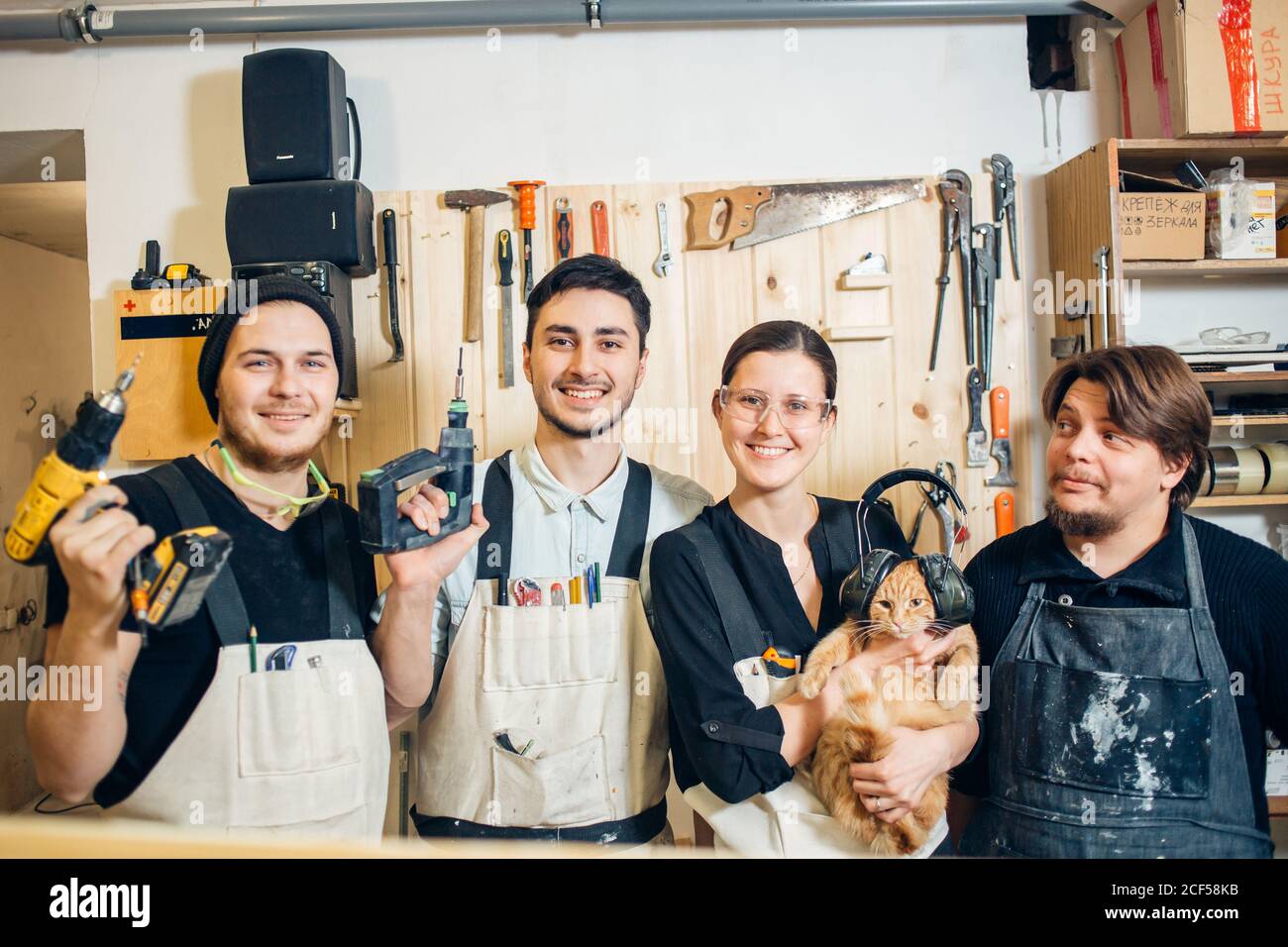 Group of carpenters with cat smiling at the camera Stock Photo - Alamy