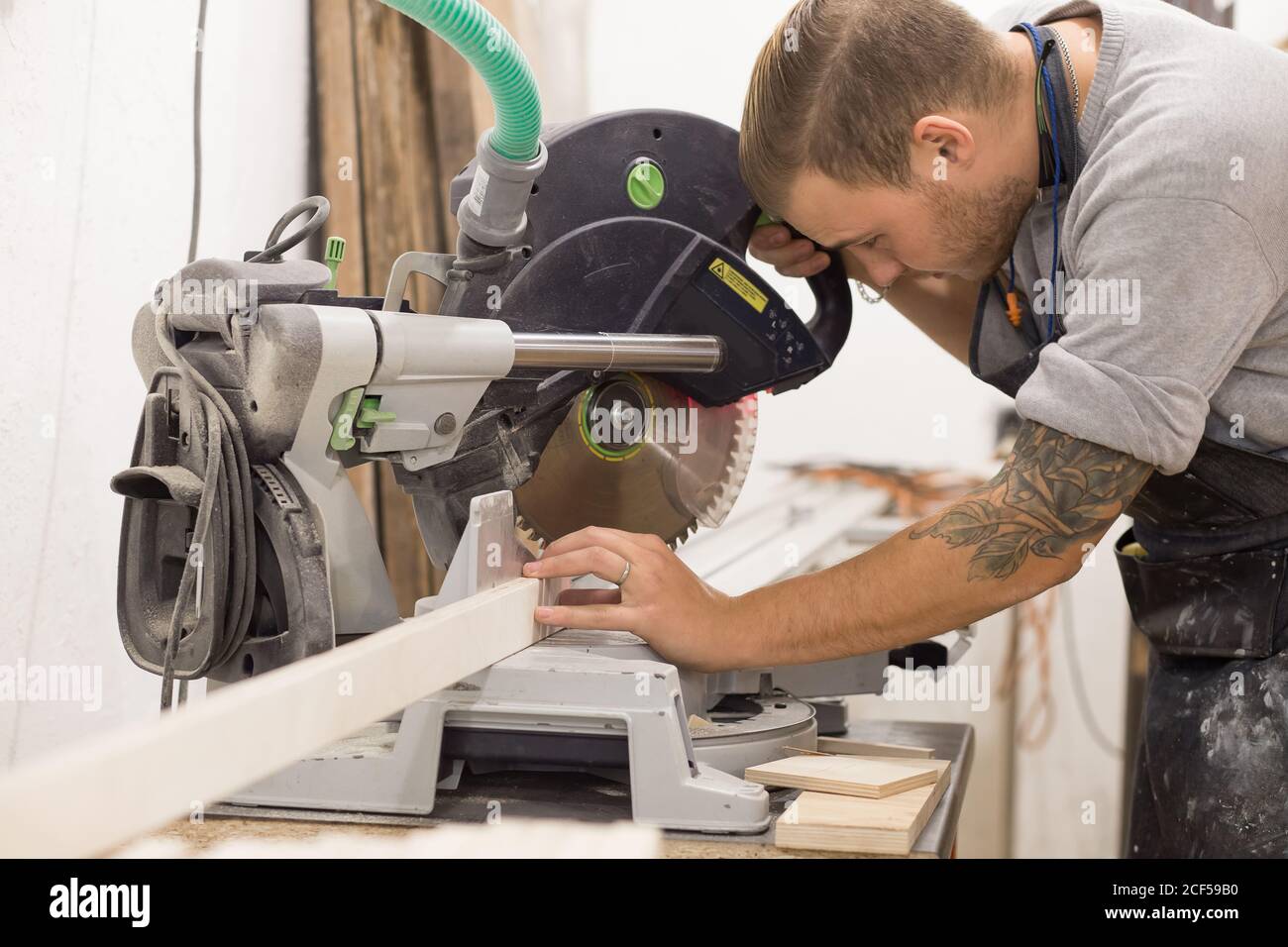 the tattooed man sawing a circular saw. carpenter work Stock Photo - Alamy