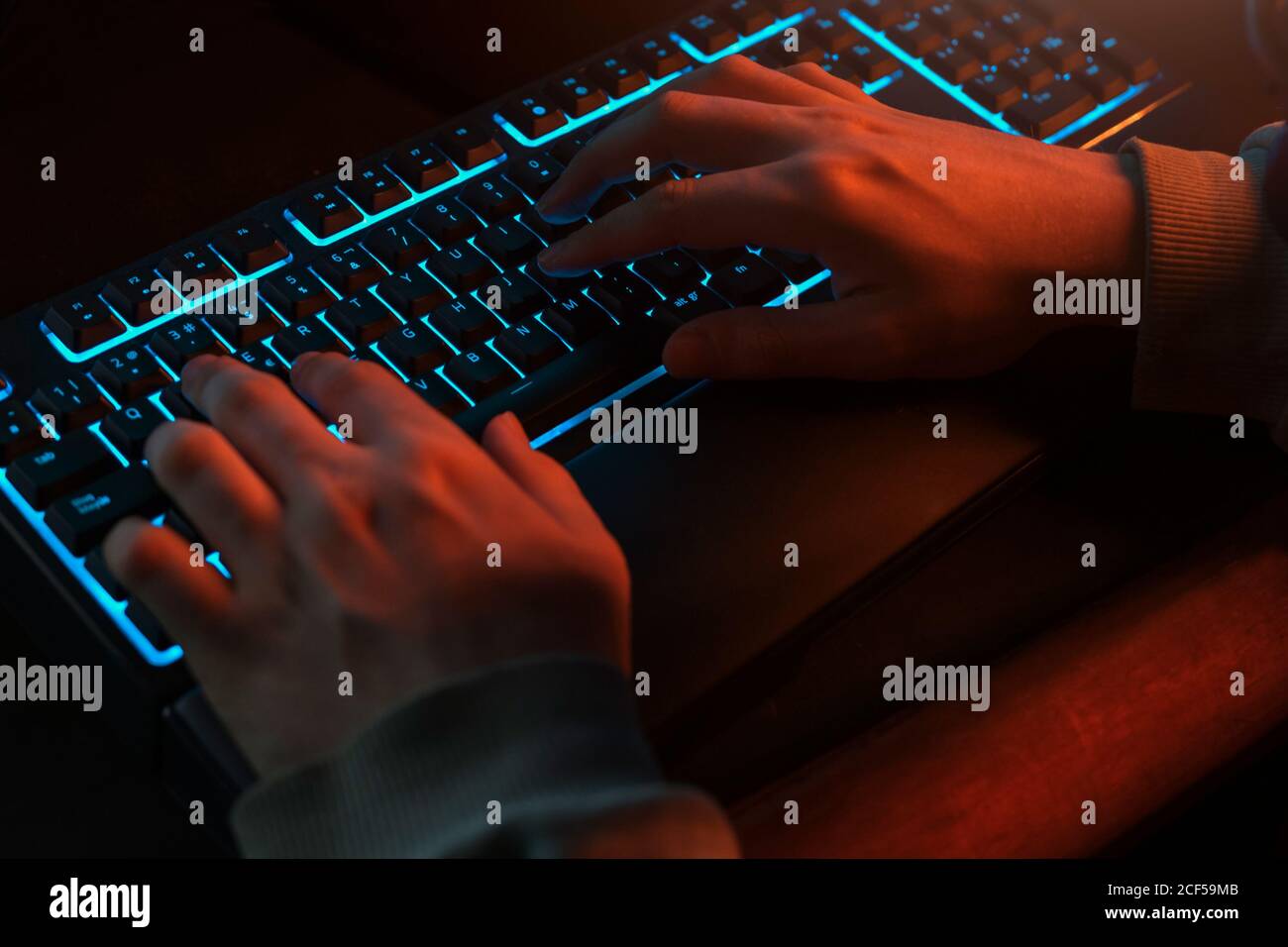 High angle of unrecognizable man in casual clothes typing on black ...