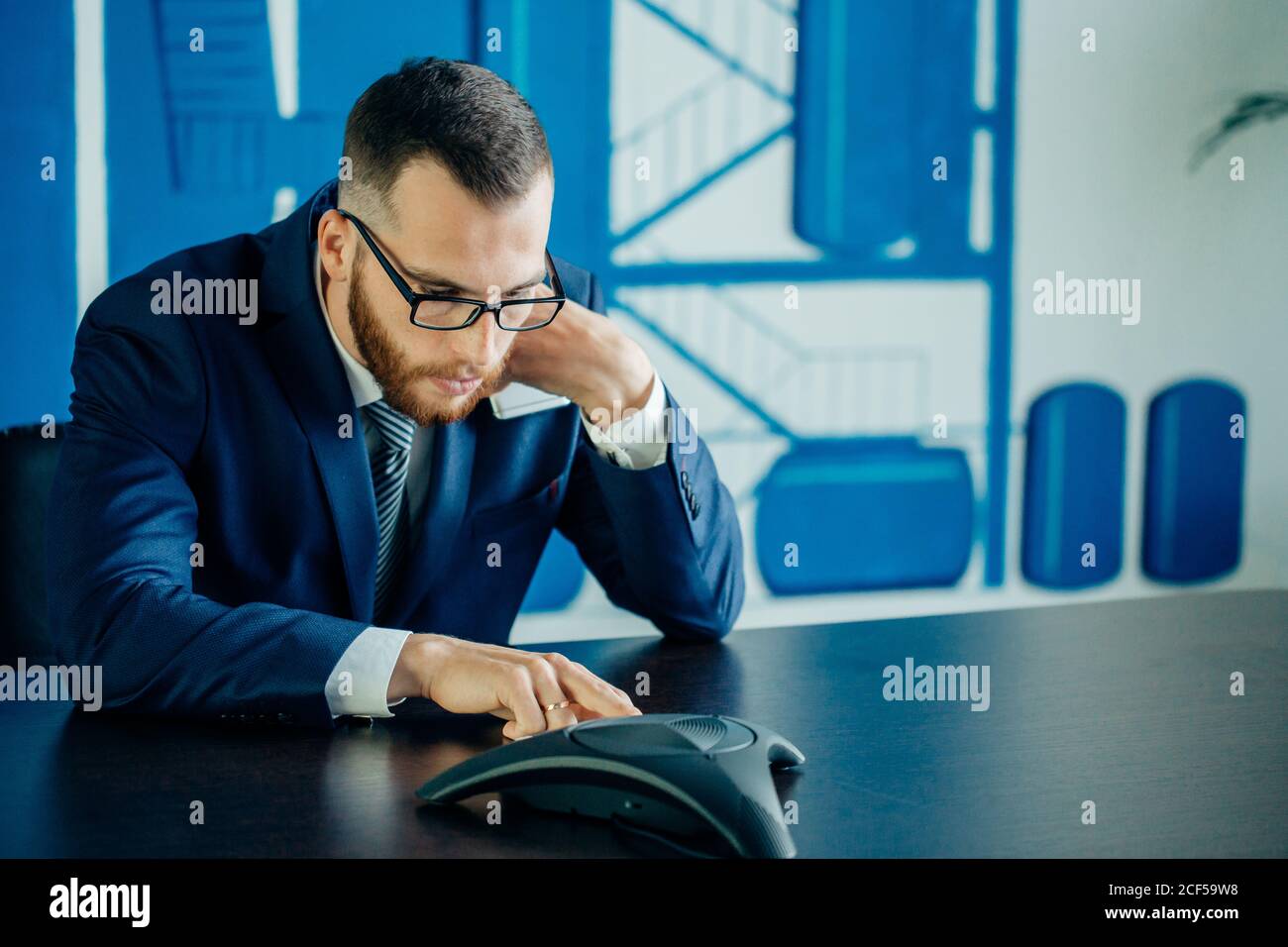 Teleconference - business people hand dialing a number on a modern ...