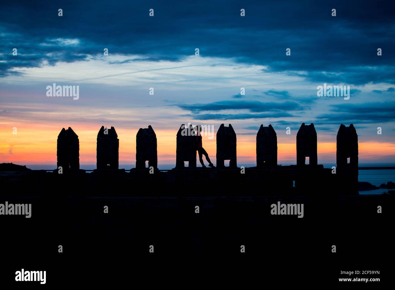 Silhouette of unrecognizable Woman standing leaning on rectangular ...