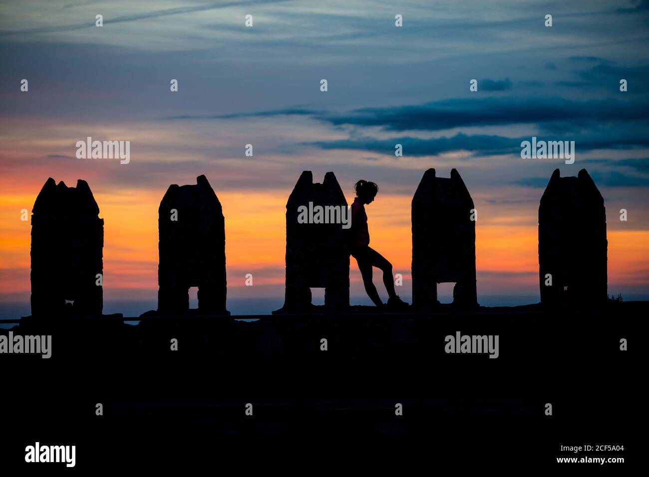 Silhouette of unrecognizable Woman standing leaning on rectangular ...