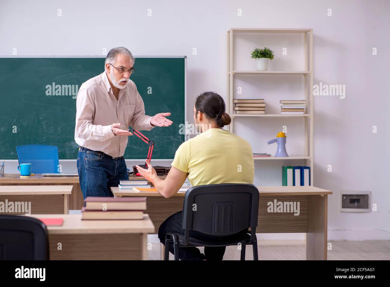 Old teacher and young student in the classroom Stock Photo - Alamy