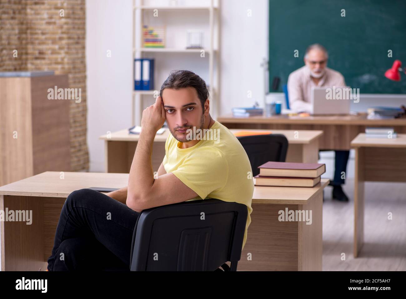 Old teacher and young student in the classroom Stock Photo - Alamy
