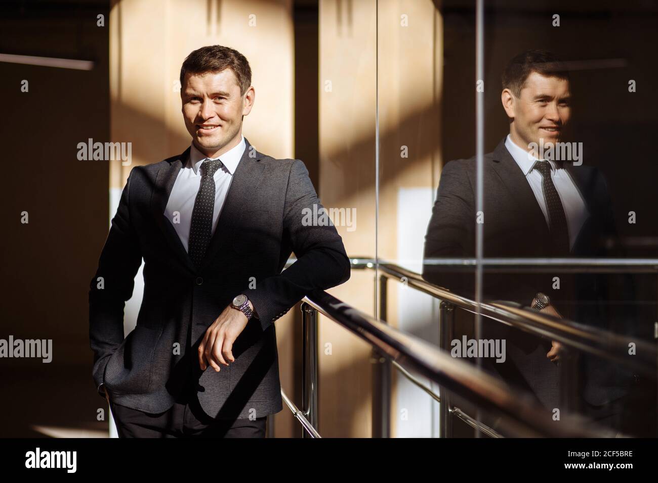 Portrait of a handsome CEO smiling at modern office Stock Photo - Alamy