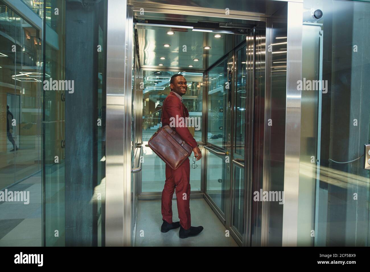 Business man exit on elevator. Business people in a large glass ...