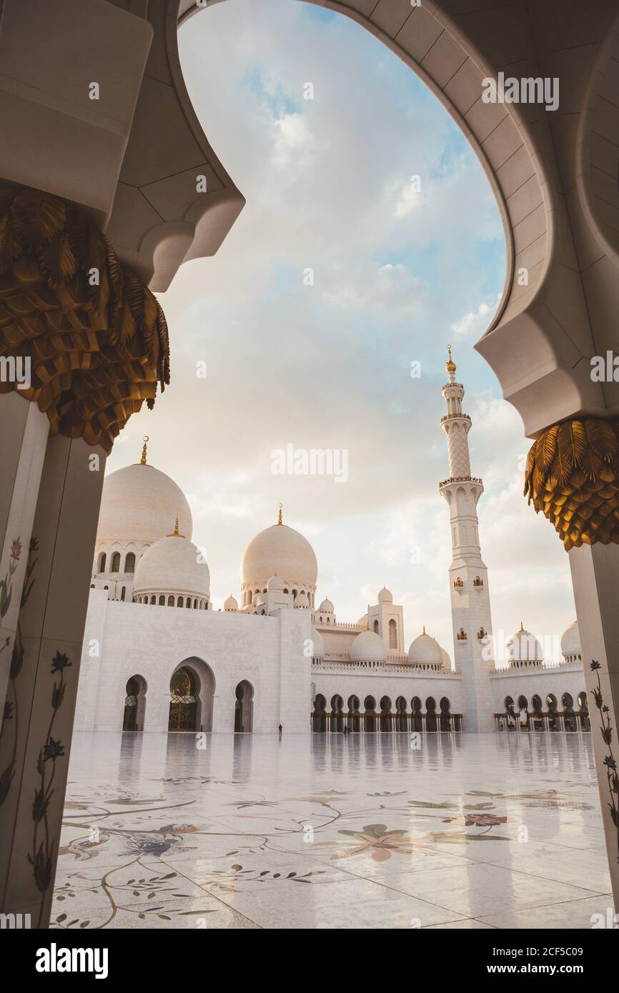 Beautiful white mosque with domes and minarets under bright blue sky ...