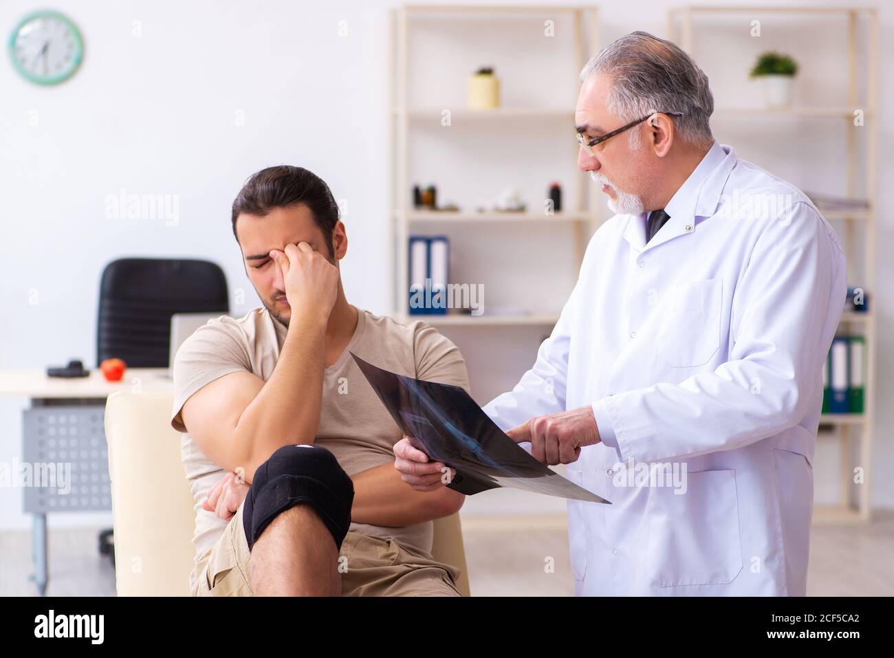 Young man visiting experienced doctor in hospital Stock Photo - Alamy