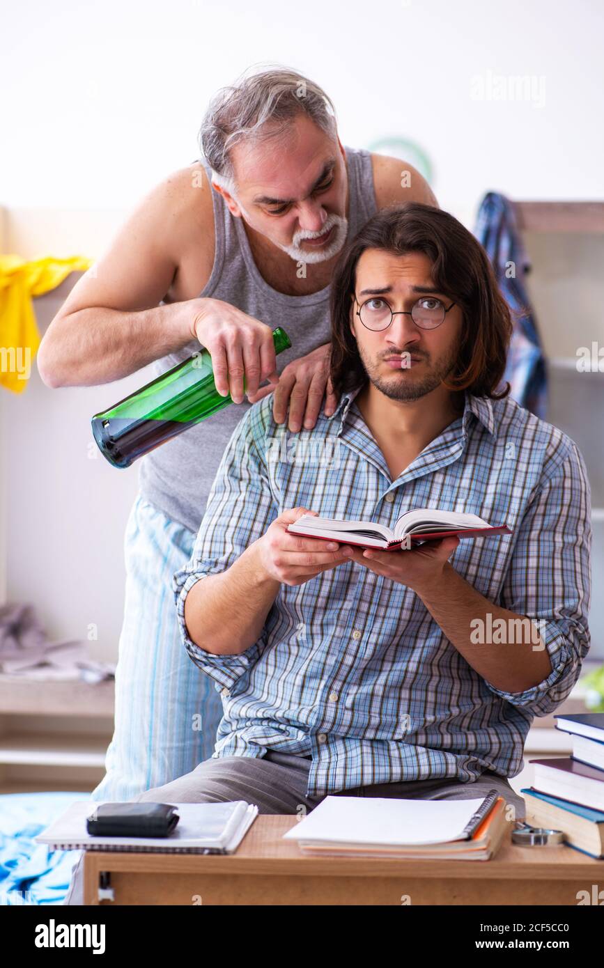 Young son student and dad alcoholic at home Stock Photo - Alamy