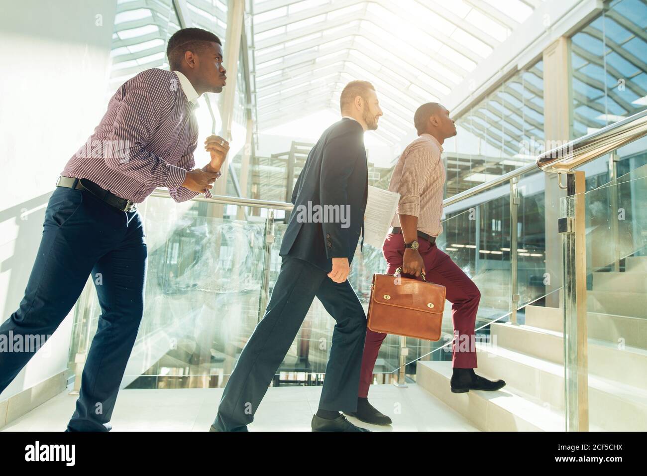 Lively business people running on steps. Concept of teamwork ...