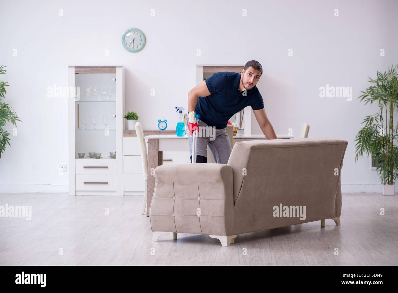 Young leg injured contractor cleaning house Stock Photo - Alamy